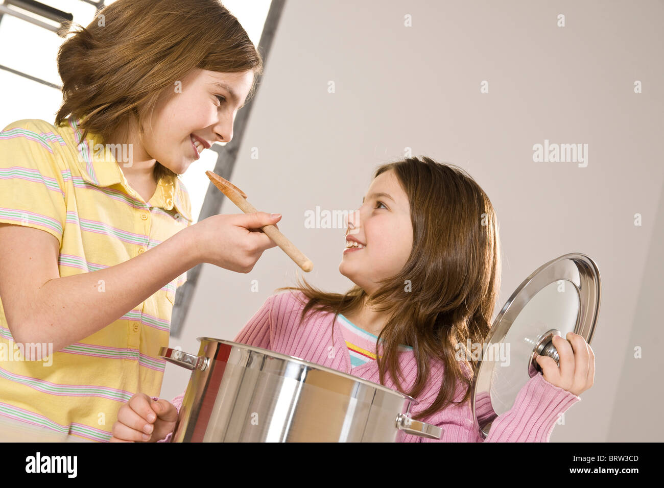Two girls having fun while cooking Stock Photo - Alamy