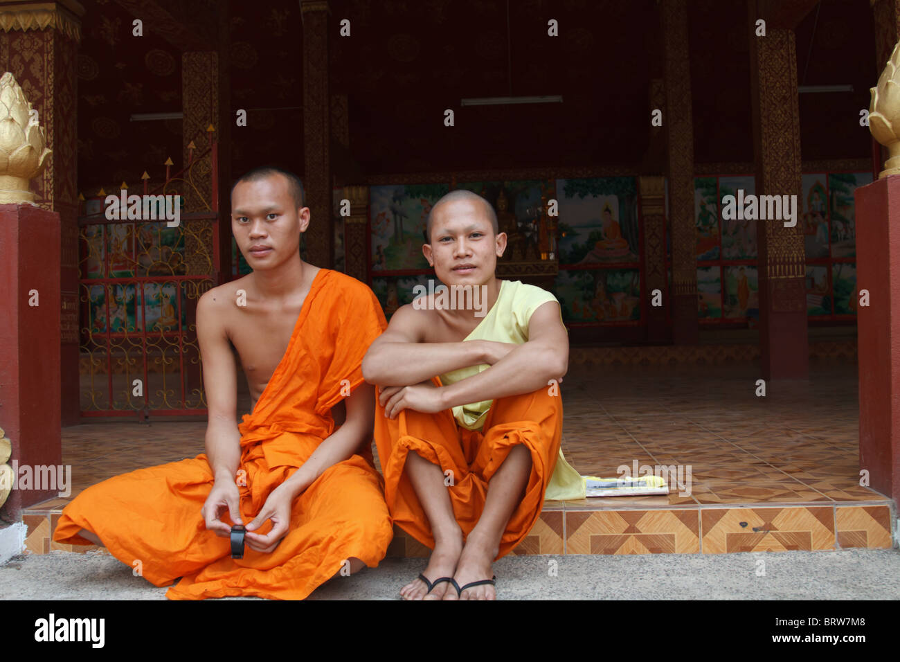 Two monks sitting in the doorway of a temple Stock Photo - Alamy