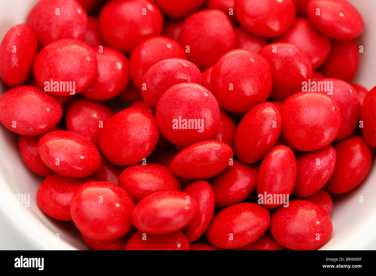 Red-coloured chocolate drops Stock Photo - Alamy