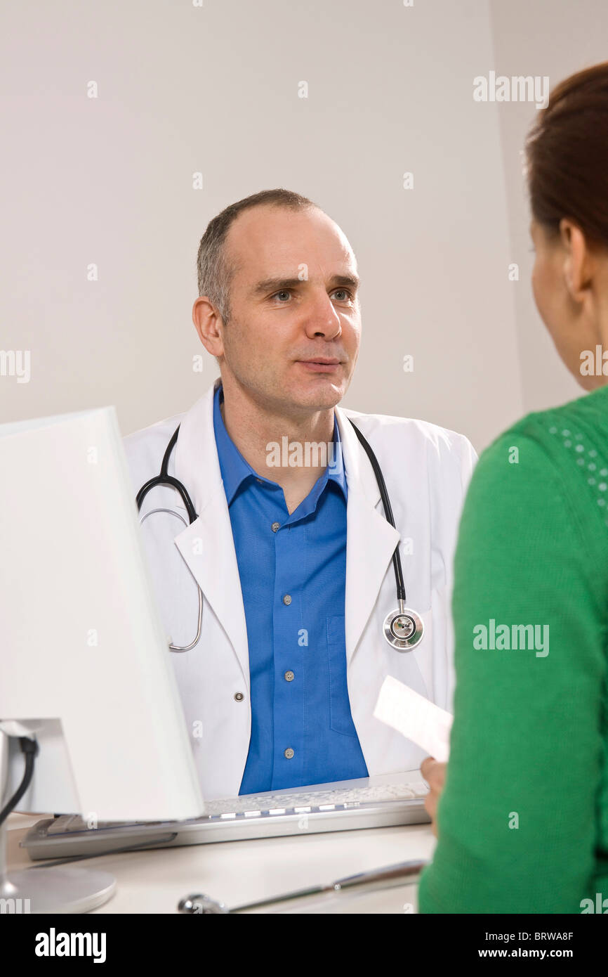 A doctor advising a female patient in his surgery Stock Photo - Alamy