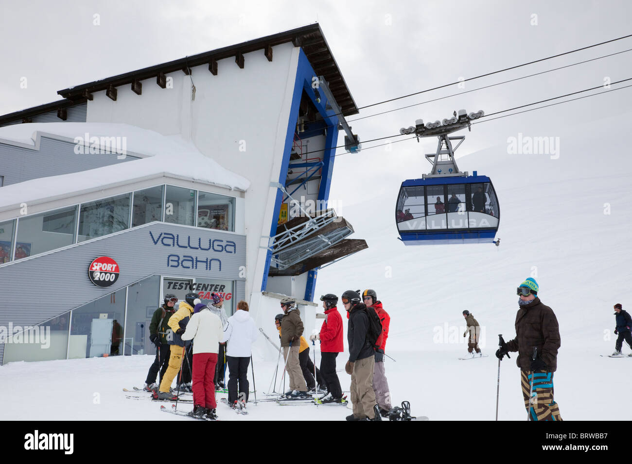 Skiers and Valluga Bahn with cable car at Galzig gondola summit station ...