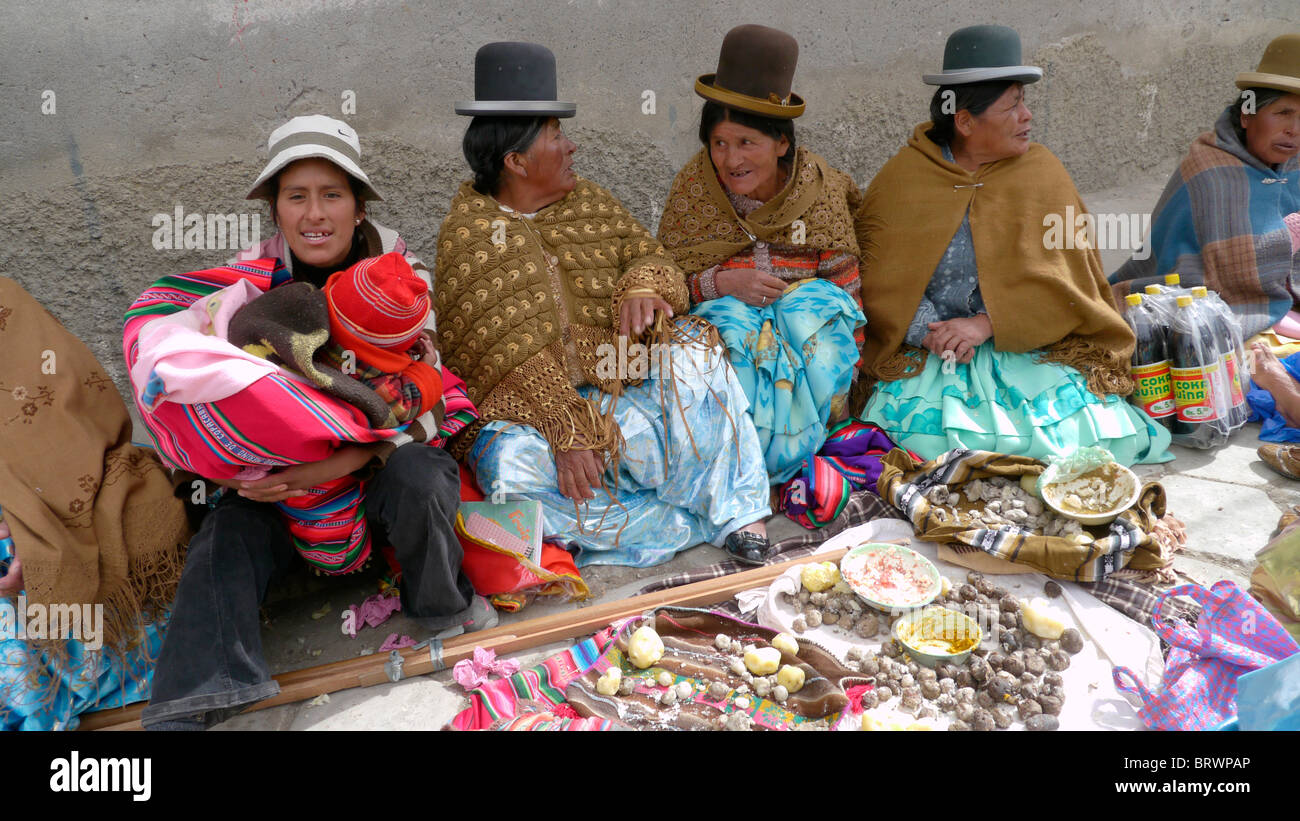 BOLIVIA Street scenes in Achacachi. Aymara women gathered to eat meal ...