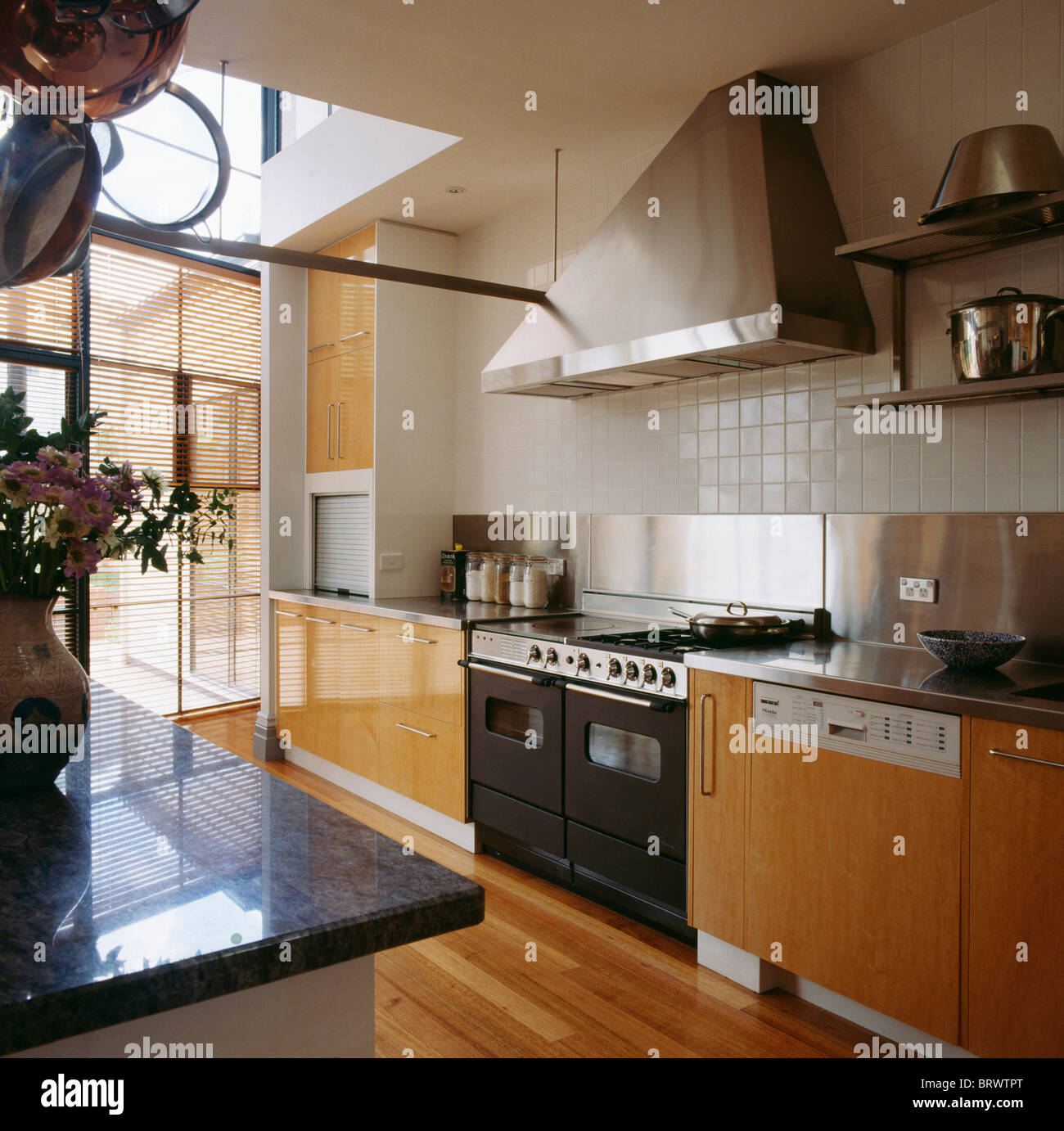 Stainless steel splash-back and extractor above range oven in modern ...