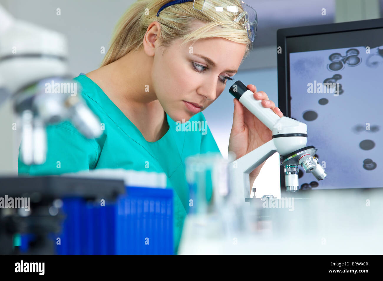A blond female medical or scientific researcher or woman doctor using ...