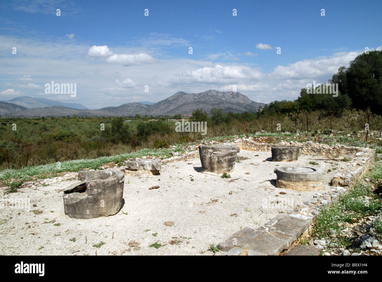 Stone olive pressing equipment with mountain backdrop at the site of a ...