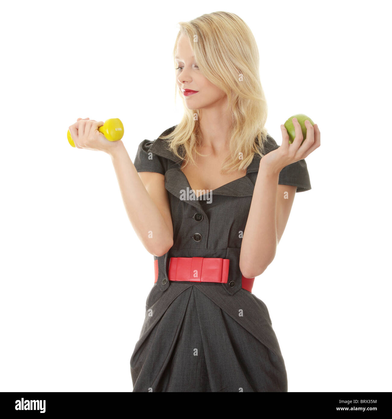 Young blond woman with green apple and yellow dumbbell - healthy living ...