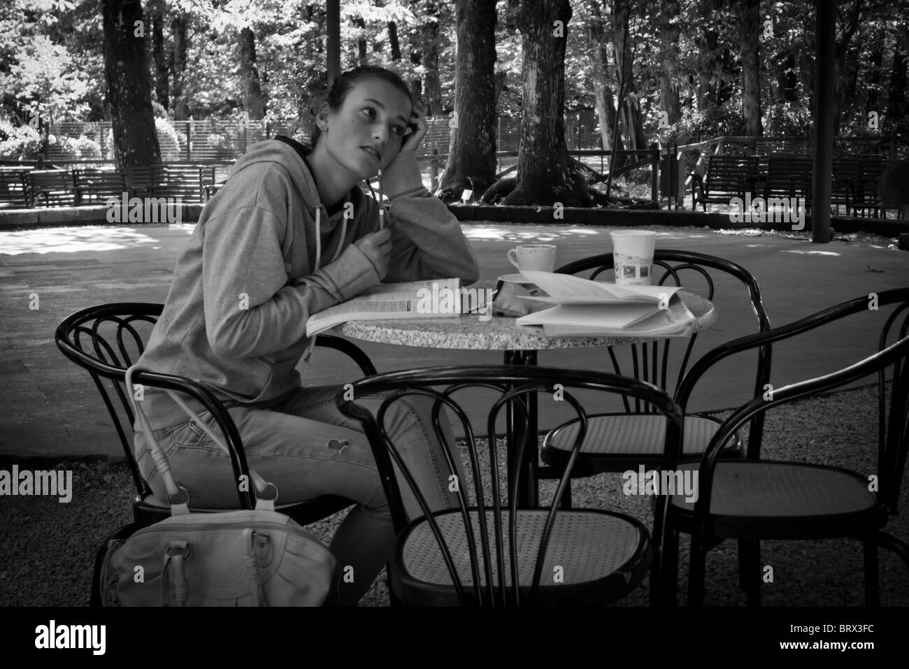 Young woman sitting and thinking on books. B&W Stock Photo - Alamy
