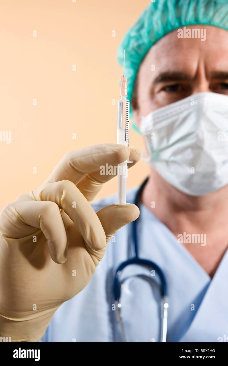 Surgeon holding a syringe Stock Photo - Alamy