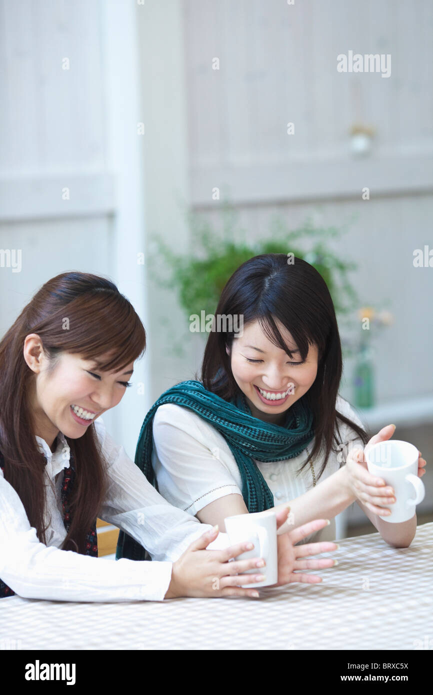 Two Young Women Drinking Tea Stock Photo - Alamy