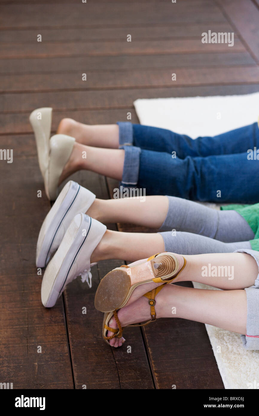 Three Women Lying on Rug Focus on Legs Stock Photo - Alamy