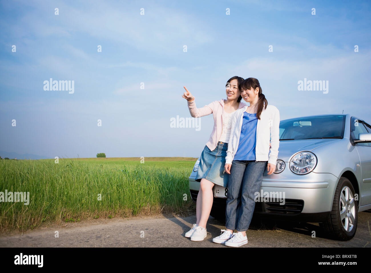 Two Female Friends Leaning on Car at Countryside Stock Photo - Alamy