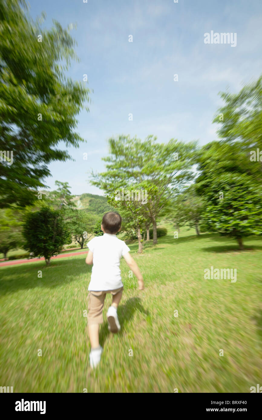 Young Boy Running in Park Stock Photo - Alamy