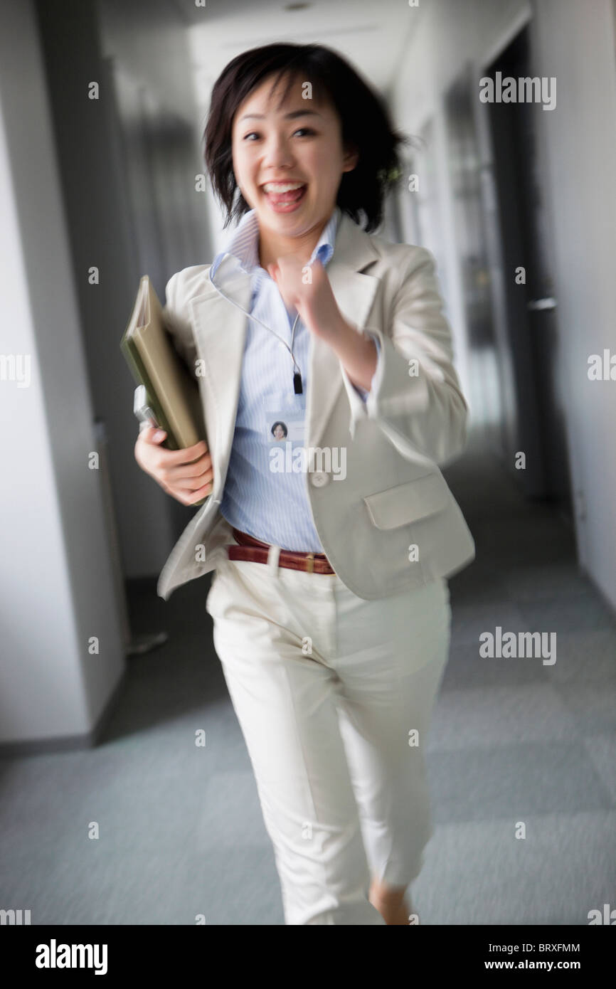 Businesswoman Running in Corridor Stock Photo - Alamy