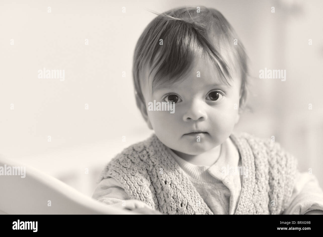 A toddler girl looks innocently from her cot Stock Photo - Alamy