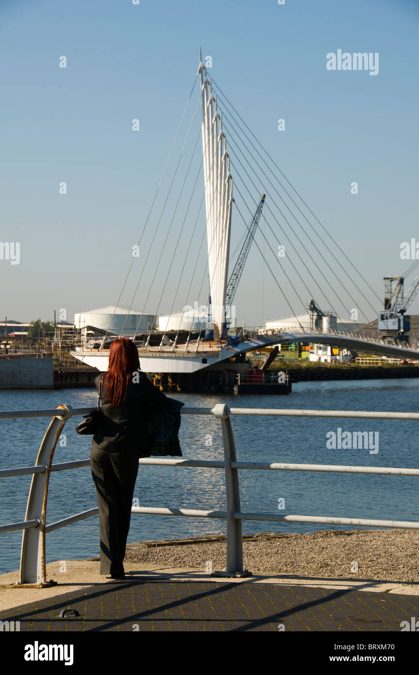 Young woman looking at the new swing footbridge under construction at ...
