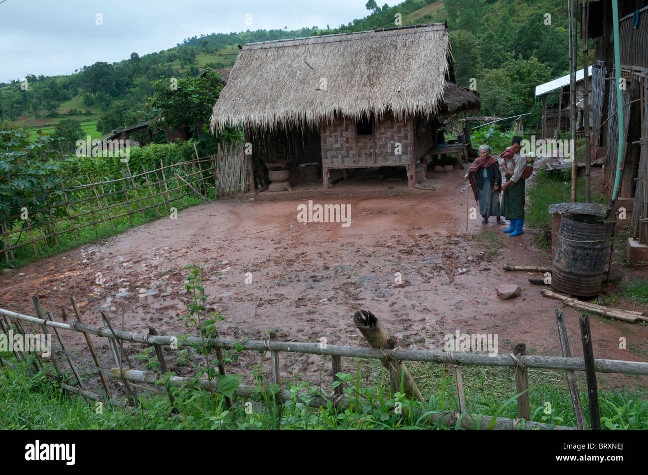 farmers standing in the muddy courtuyard of their farm in a Shan Hills ...