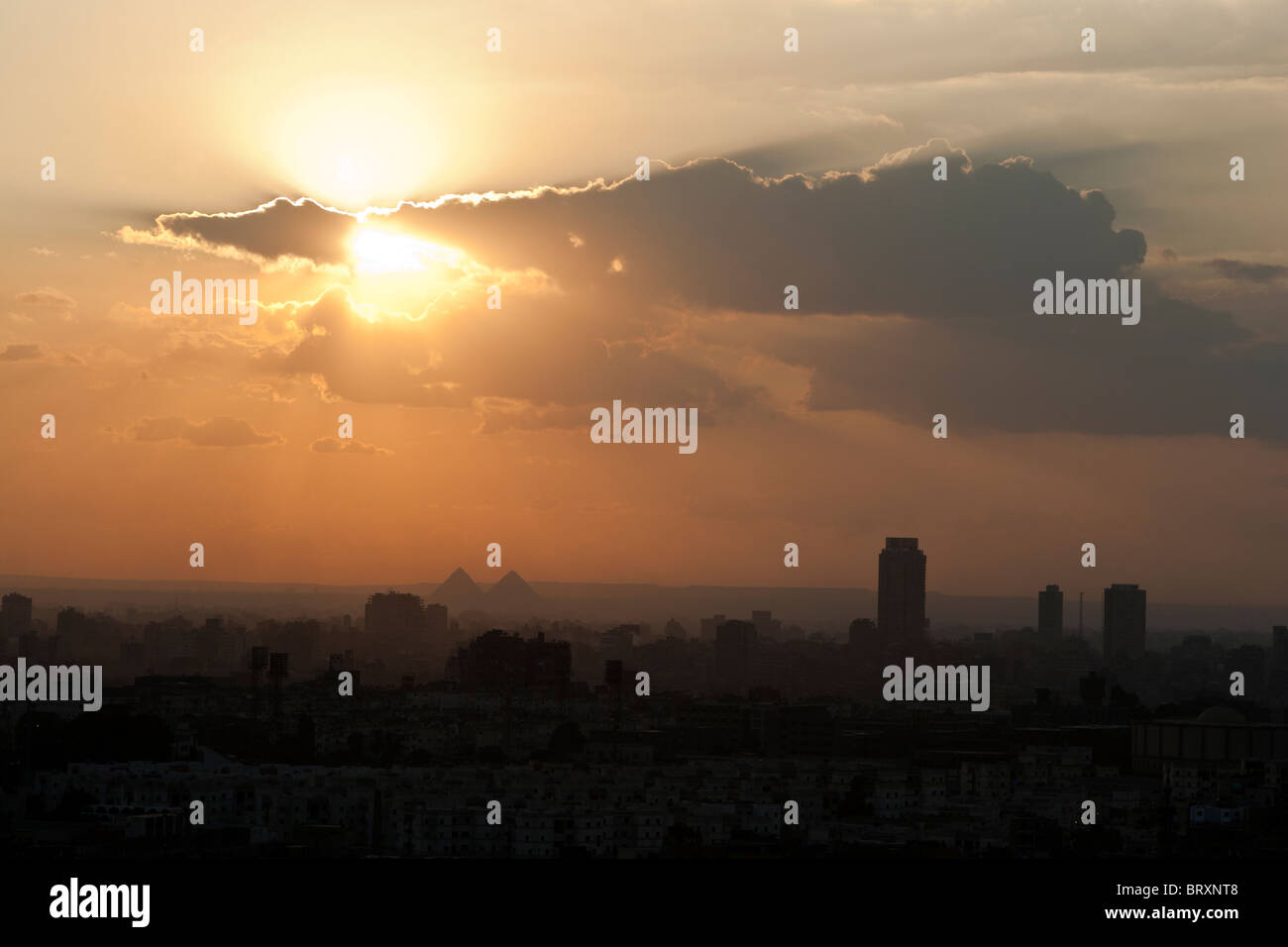 Sunset over Cairo with an outline of the Great Pyramids on the horizon ...