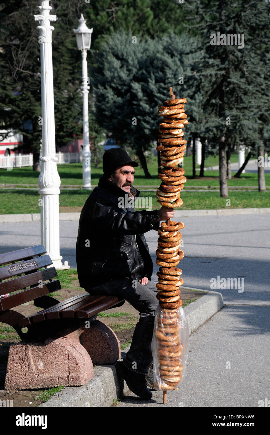 man selling bread food snack piled on a pole outside blue mosque ...
