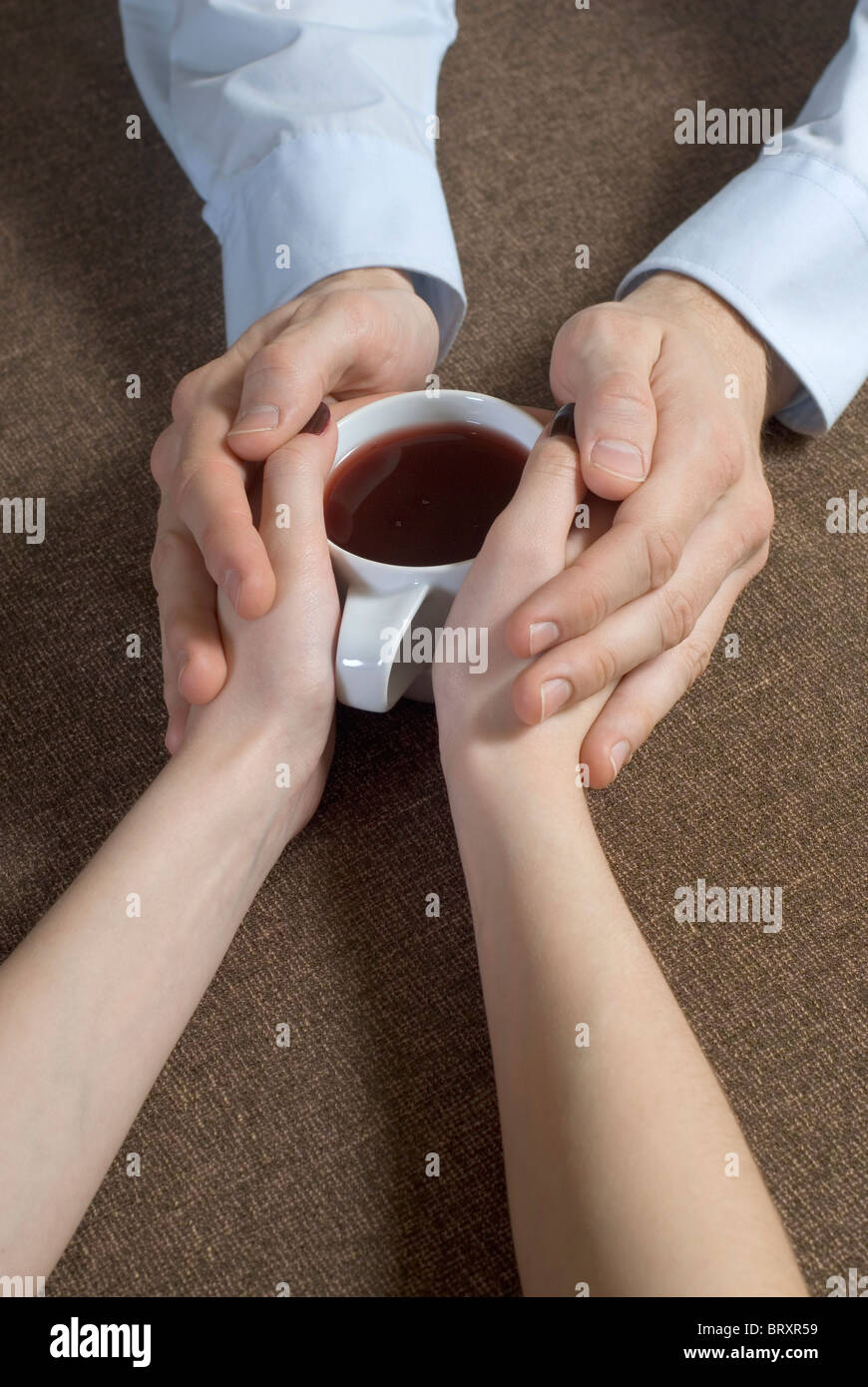 Close-up of young couple hand's holding tea cup together Stock Photo ...