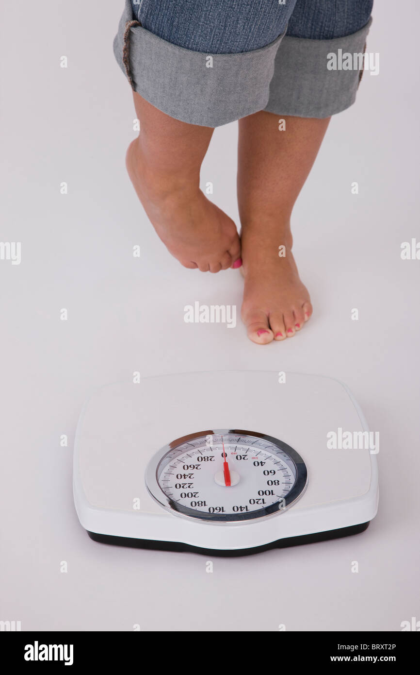 Low section of woman standing in front of weight scales Stock Photo - Alamy