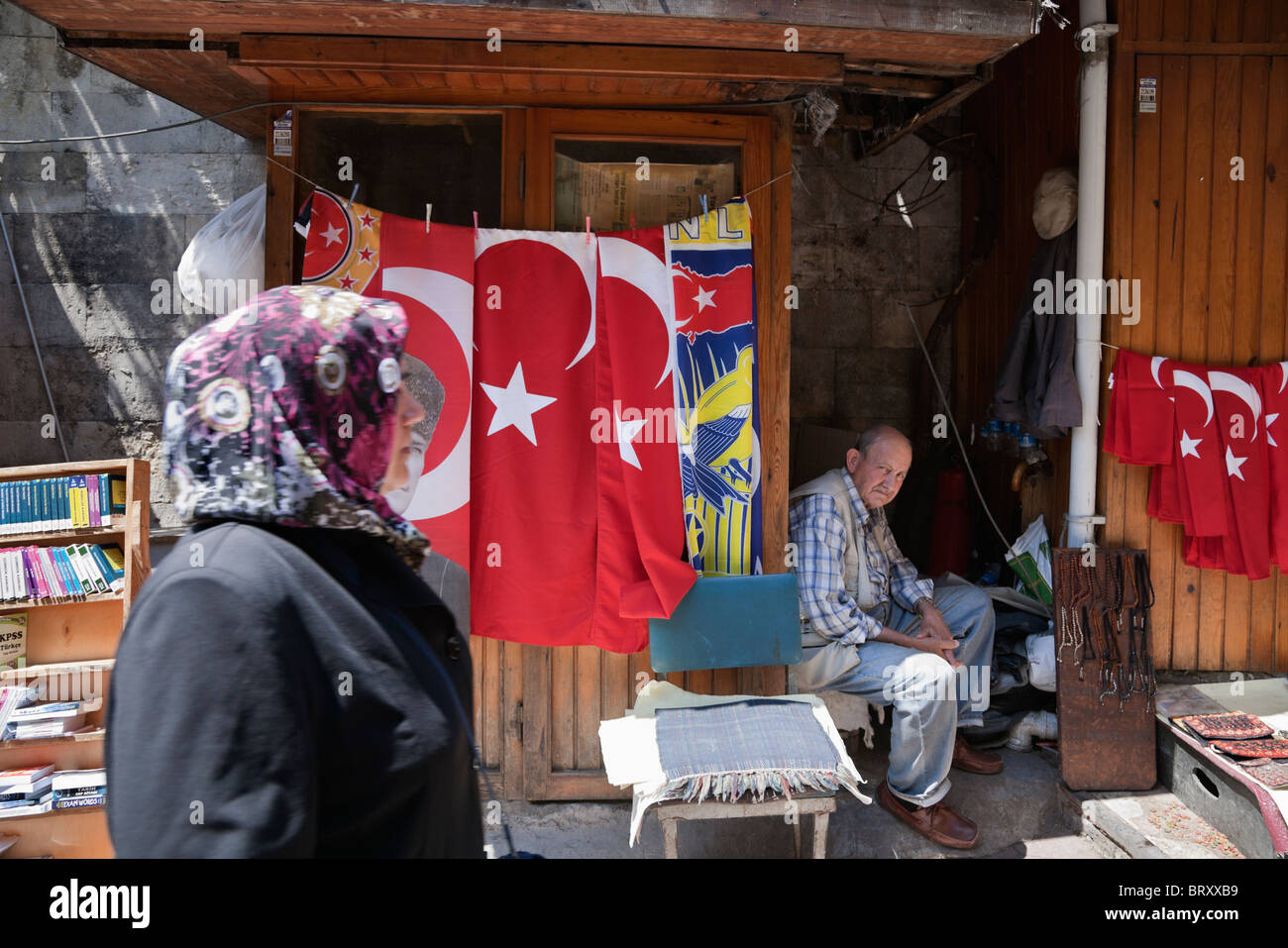Woman wearing a headscarf walks past a stall selling Turkish flags in ...