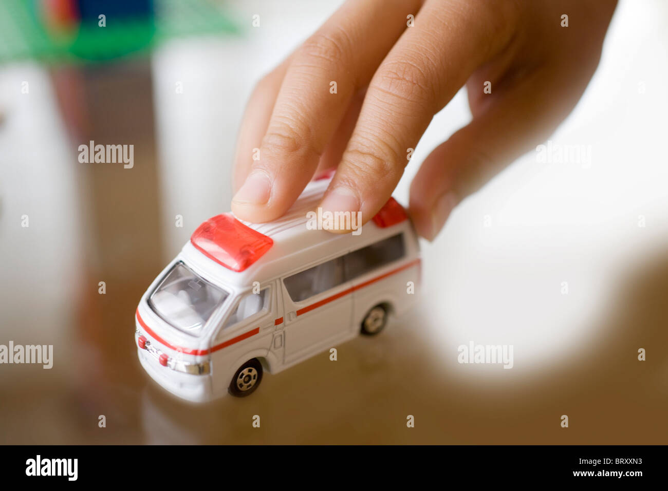 Hand holding a toy of ambulance Stock Photo - Alamy
