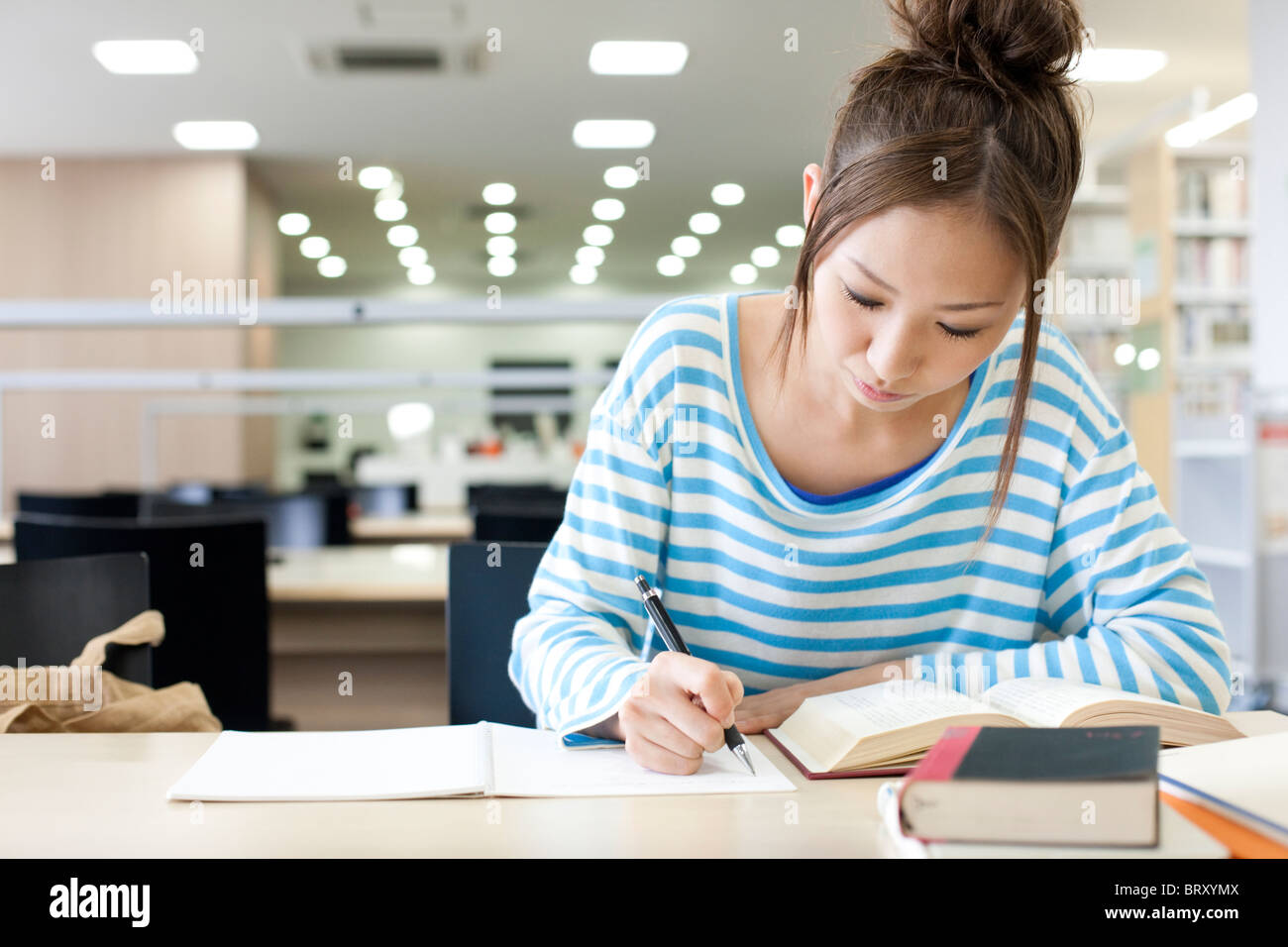 Young woman studying in a library Japan Stock Photo - Alamy