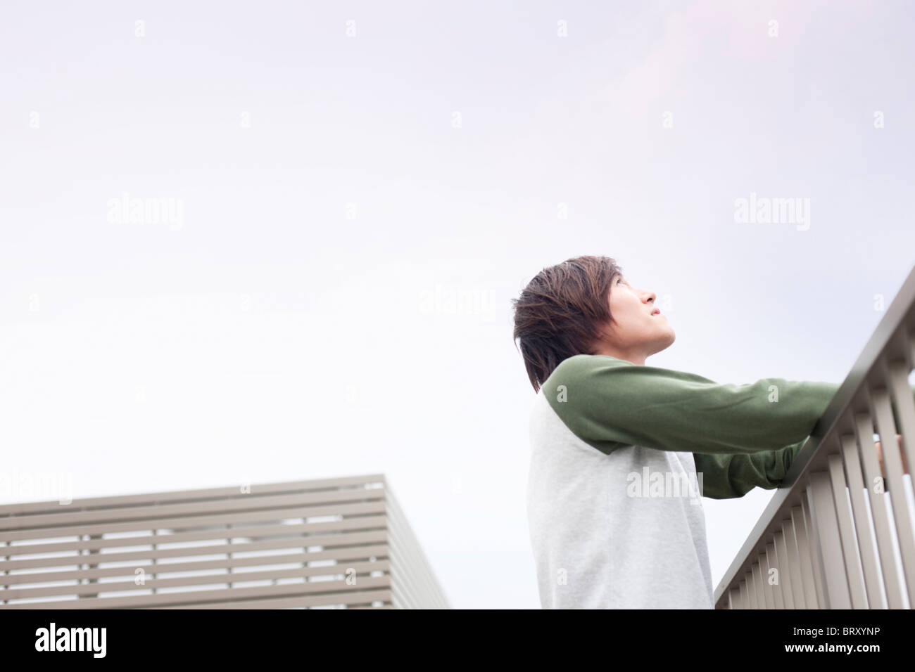 Young man looking up on a rooftop Japan Stock Photo - Alamy