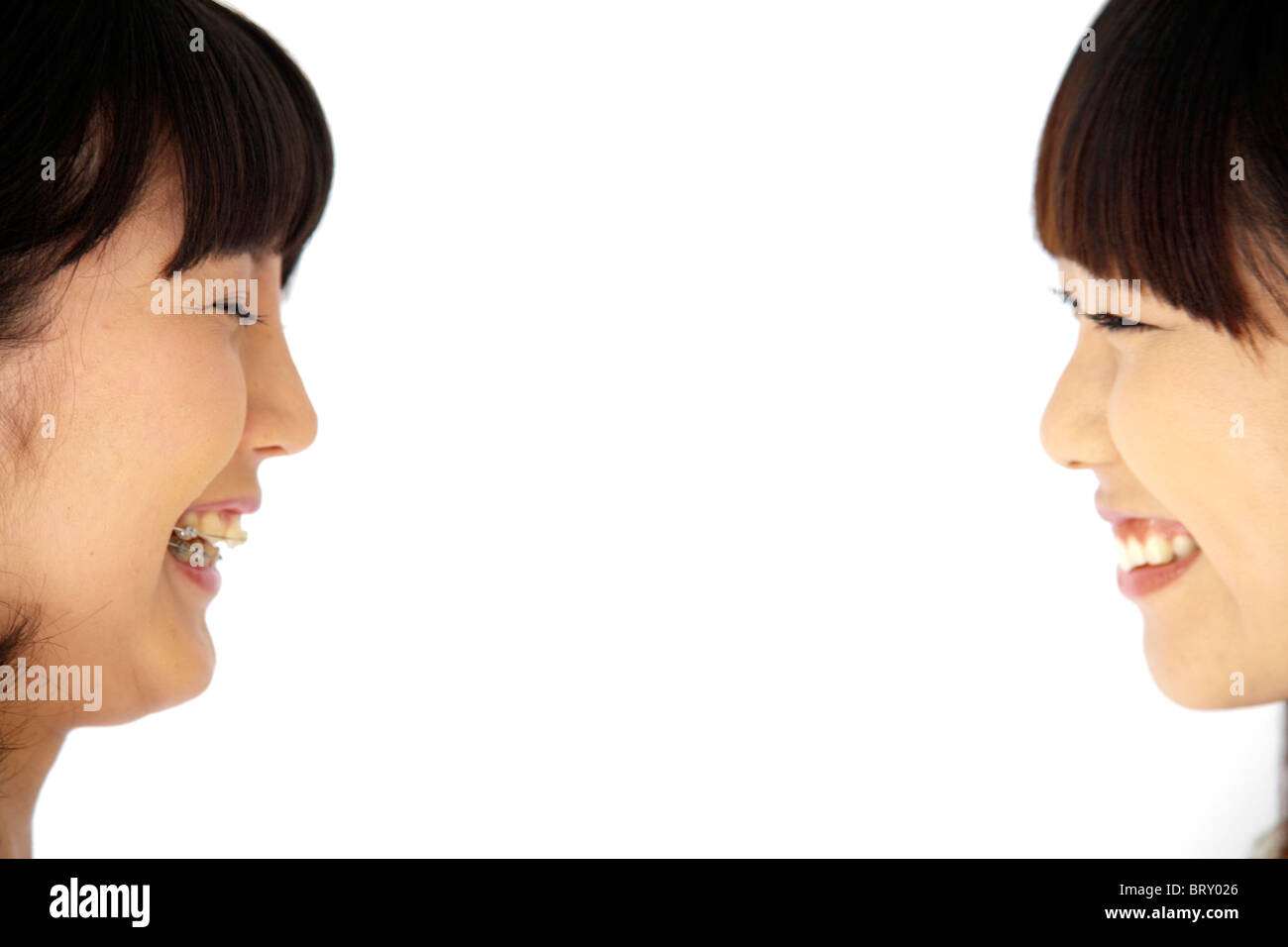 Two Young Women Smiling at Each Other Stock Photo - Alamy