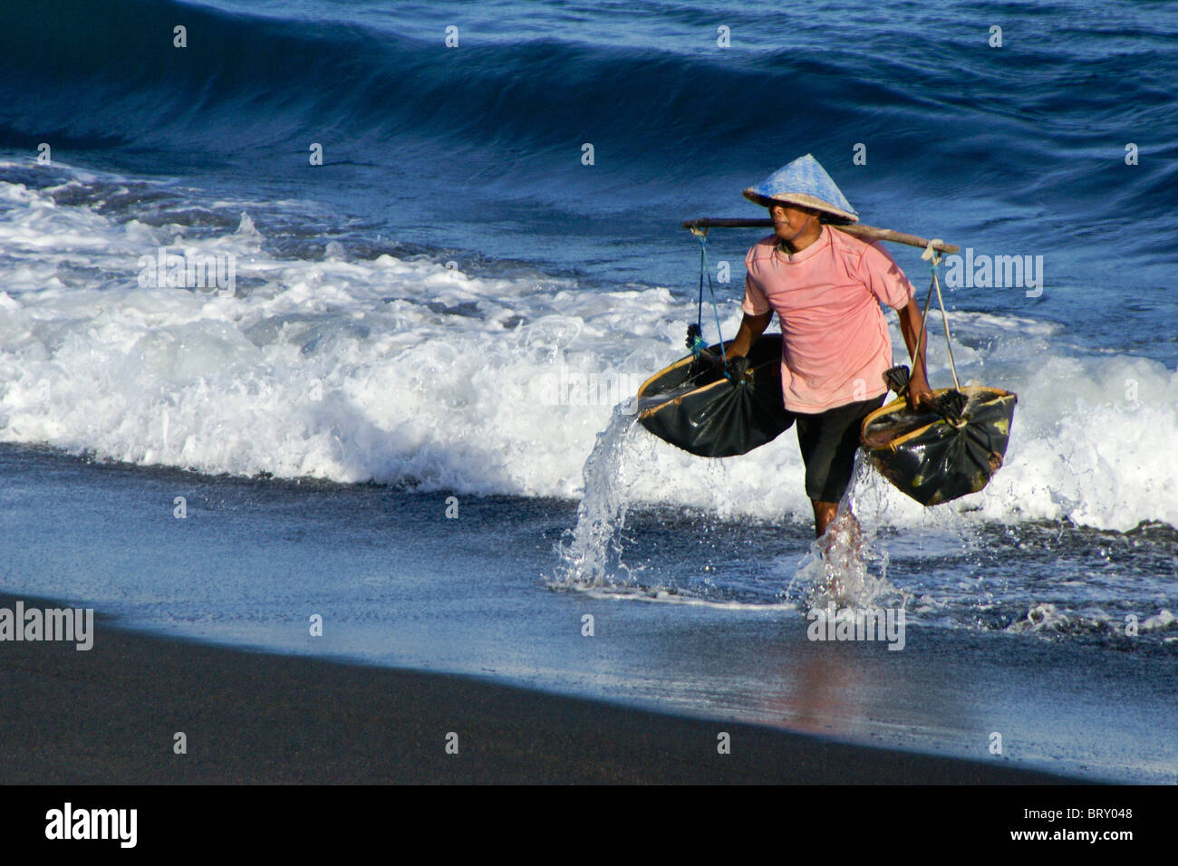 Man carrying sea water to make salt, Kusamba, Bali, Indonesia Stock ...