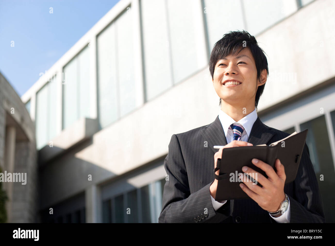 A businessman holding a notebook Stock Photo - Alamy