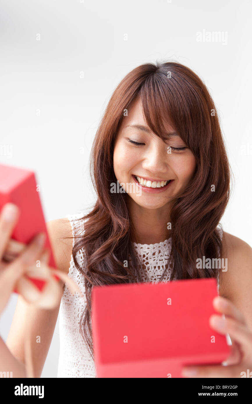 Young woman opening present box, white background Stock Photo - Alamy