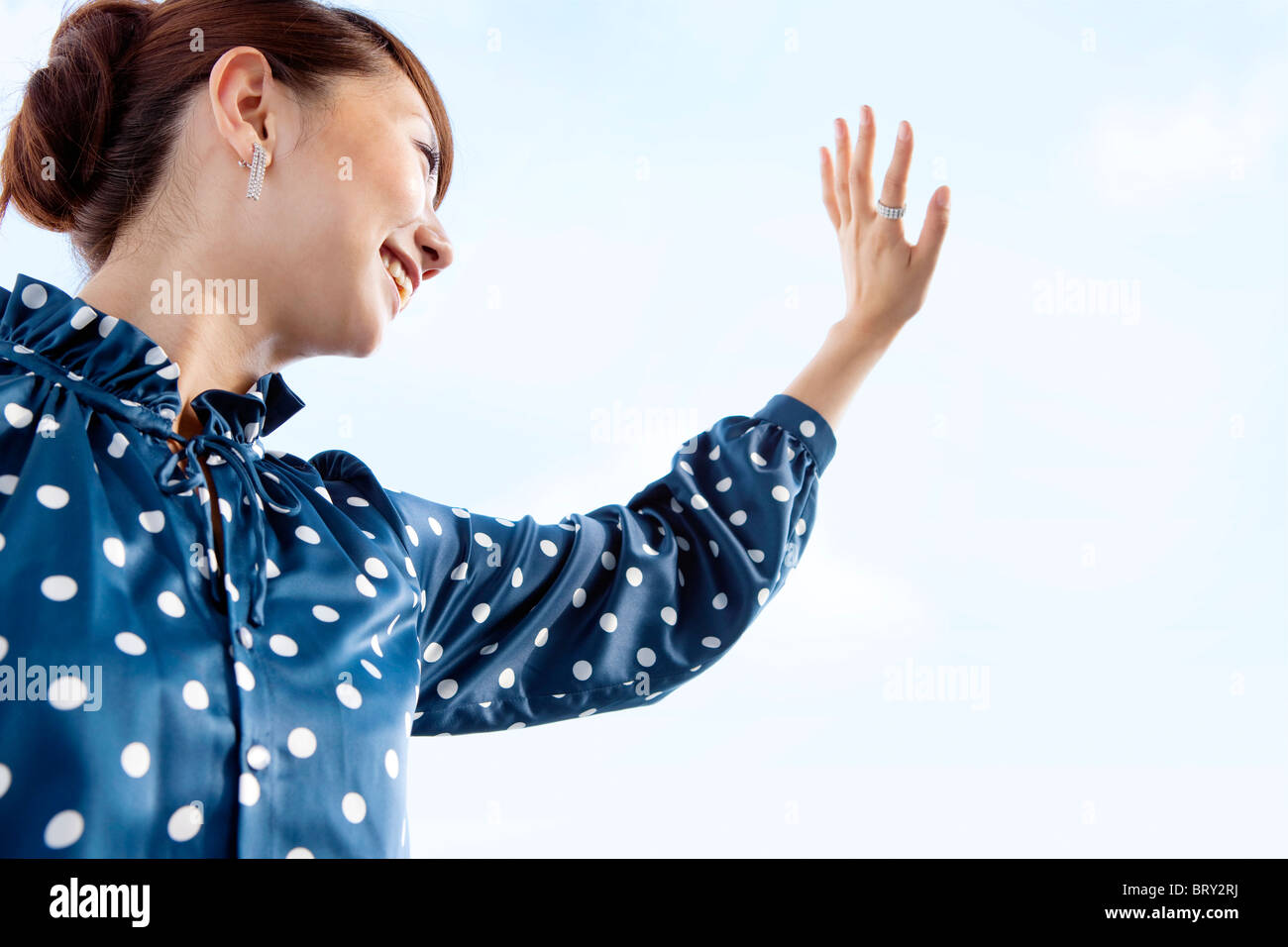 Young woman waving hand, smiling Stock Photo - Alamy