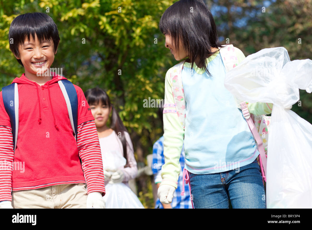 School children carrying bags for recycling Stock Photo - Alamy