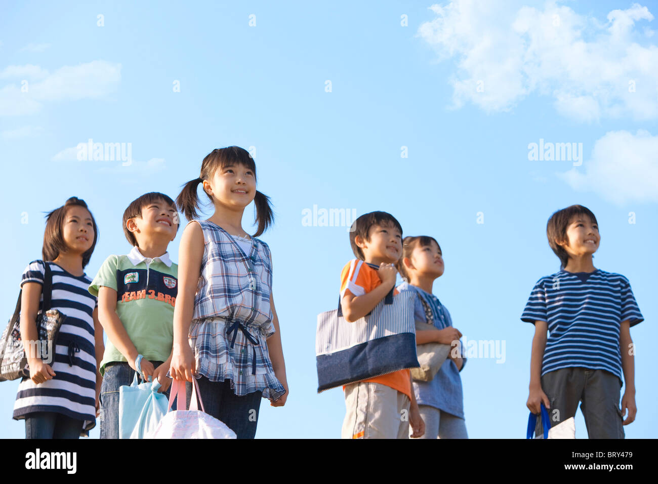School children standing under sky, looking away, copy space Stock ...