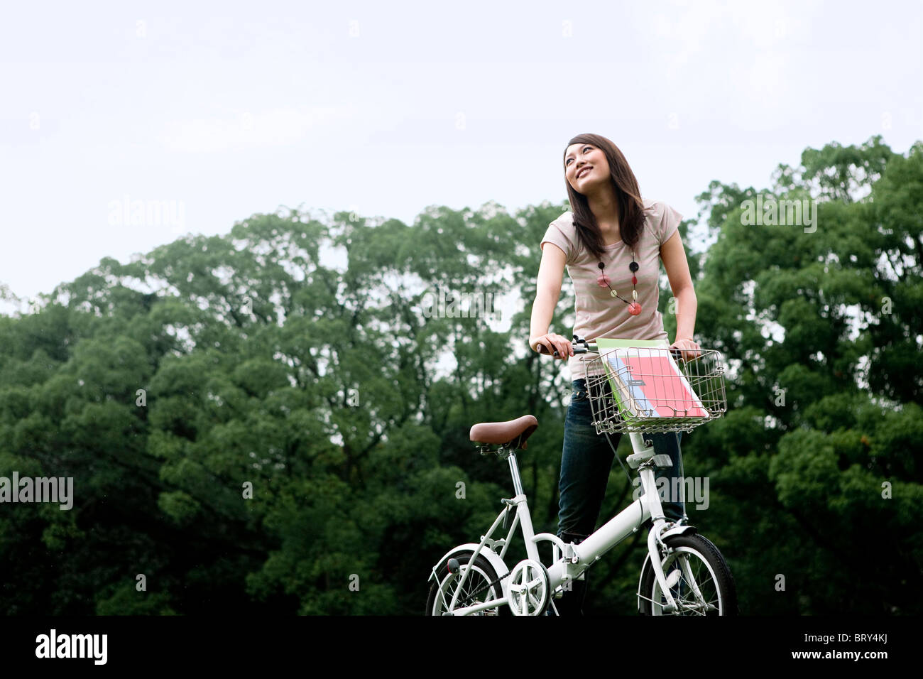 Young woman pushing bicycle, smiling Stock Photo - Alamy