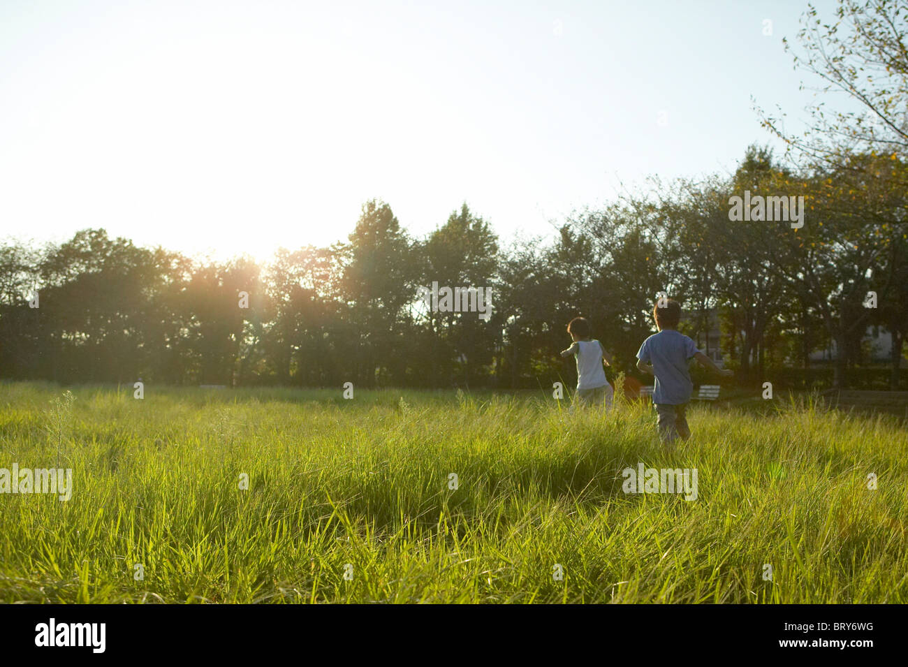 Boys running in field Stock Photo - Alamy
