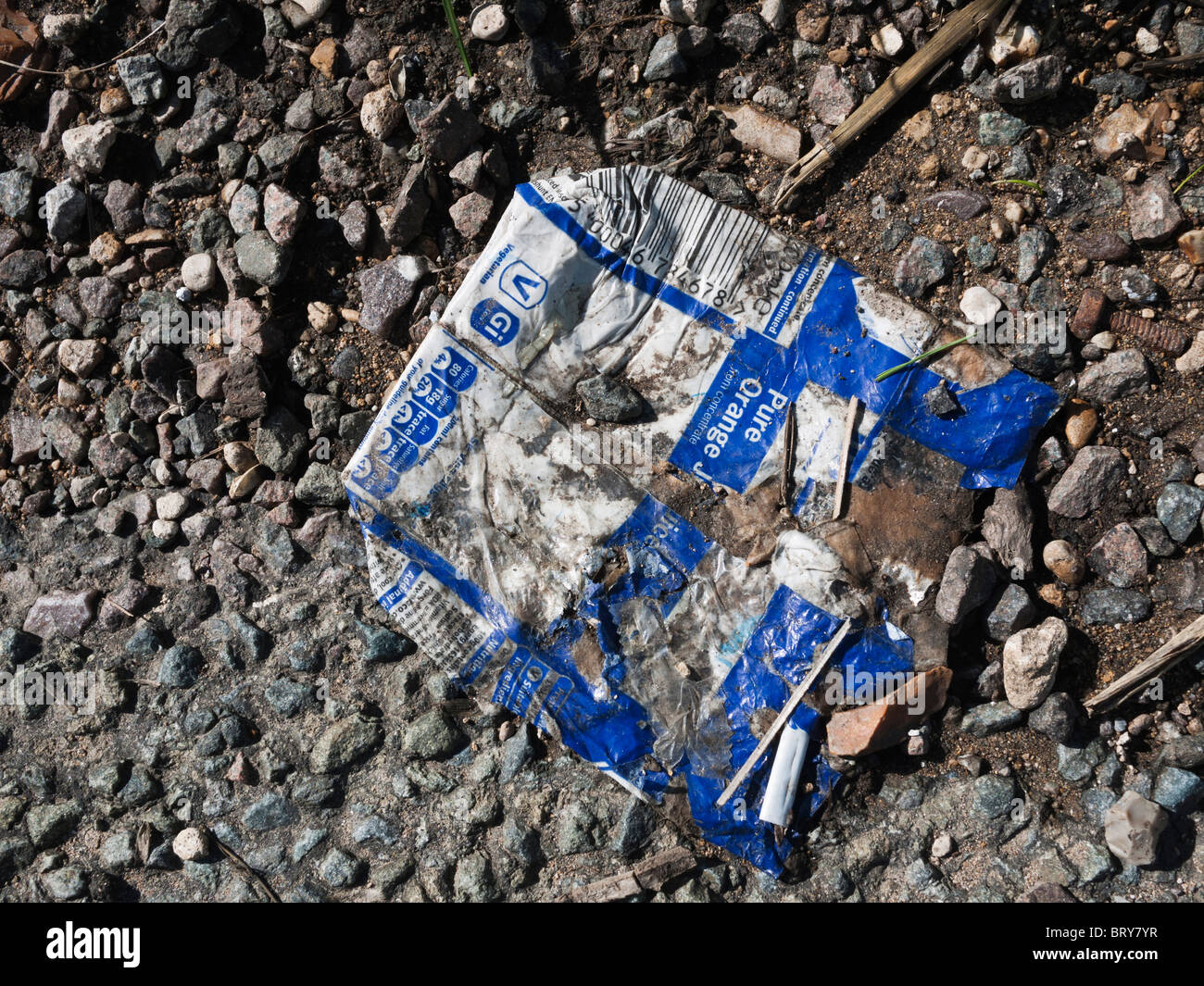 Squashed small cardboard carton of orange on roadside Stock Photo - Alamy