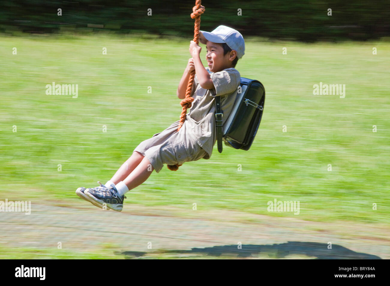 Boy on rope swing, Japan Stock Photo - Alamy
