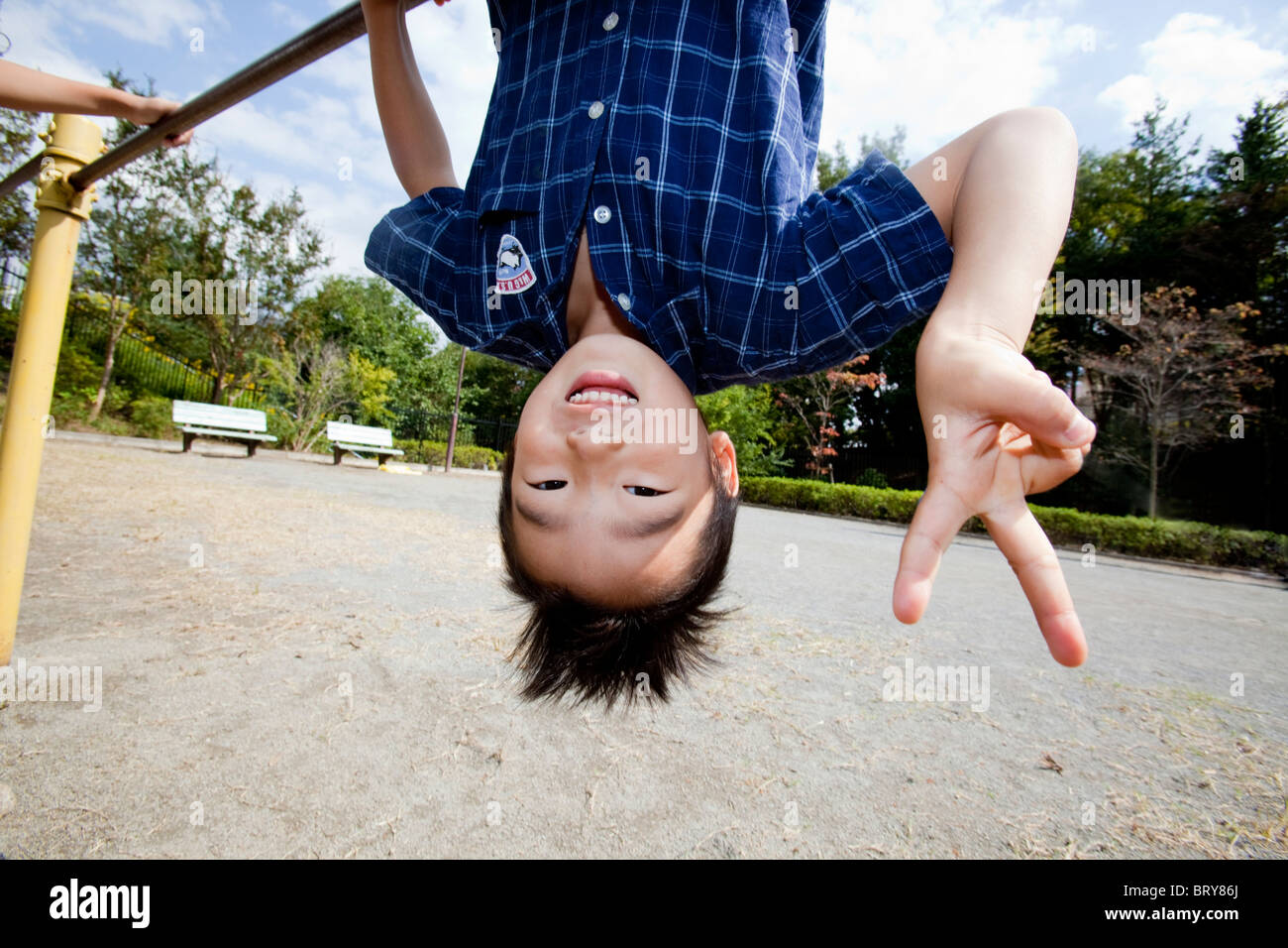 Boy hanging from the gymnastics bar, Japan Stock Photo - Alamy