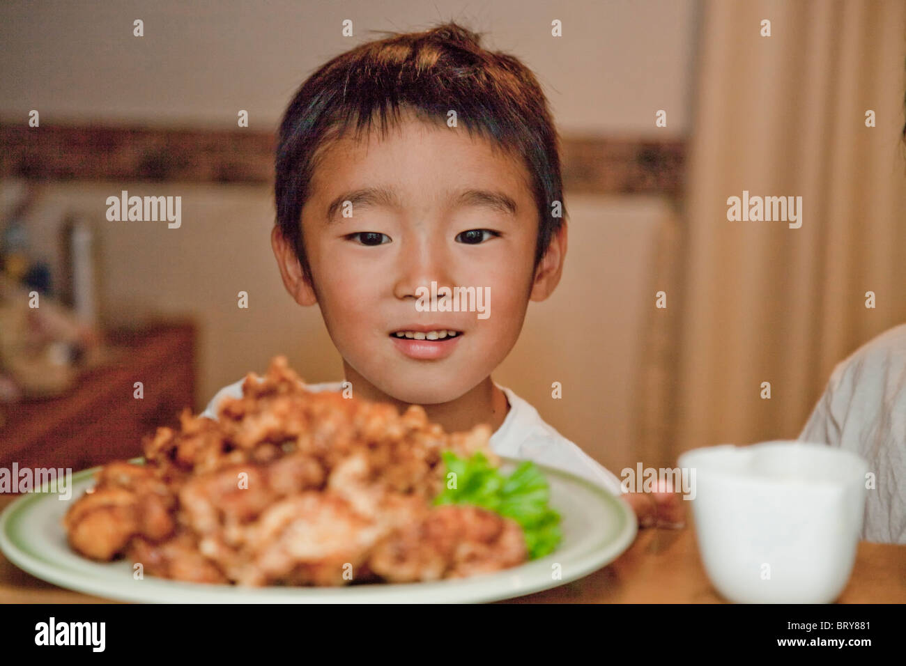 Boy looking at fried chicken, Japan Stock Photo - Alamy