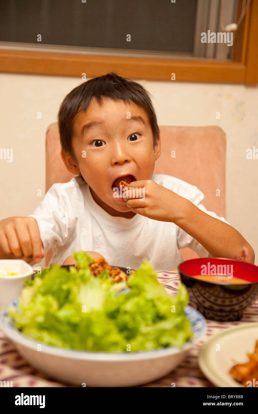 Boy eating fried chicken, Japan Stock Photo - Alamy