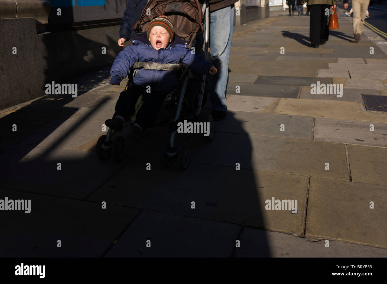 A young boy in a pushchair yawns during an exhausting daytrip to London ...