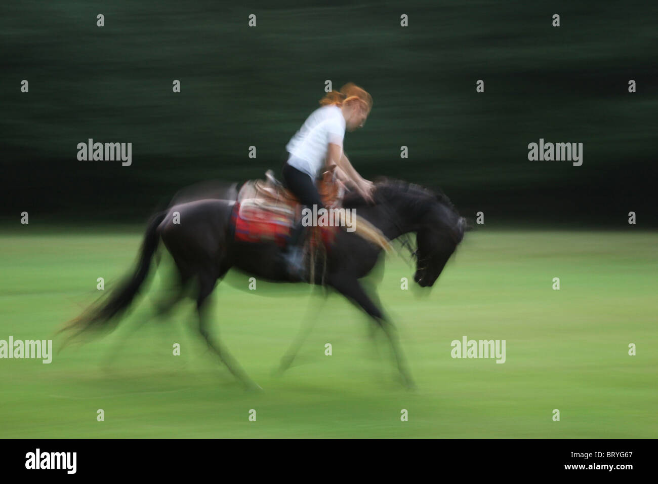 Red-haired woman galloping. Motion blur effect Stock Photo - Alamy