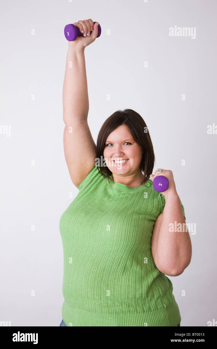 Portrait of young overweight woman exercising with dumbbells Stock ...