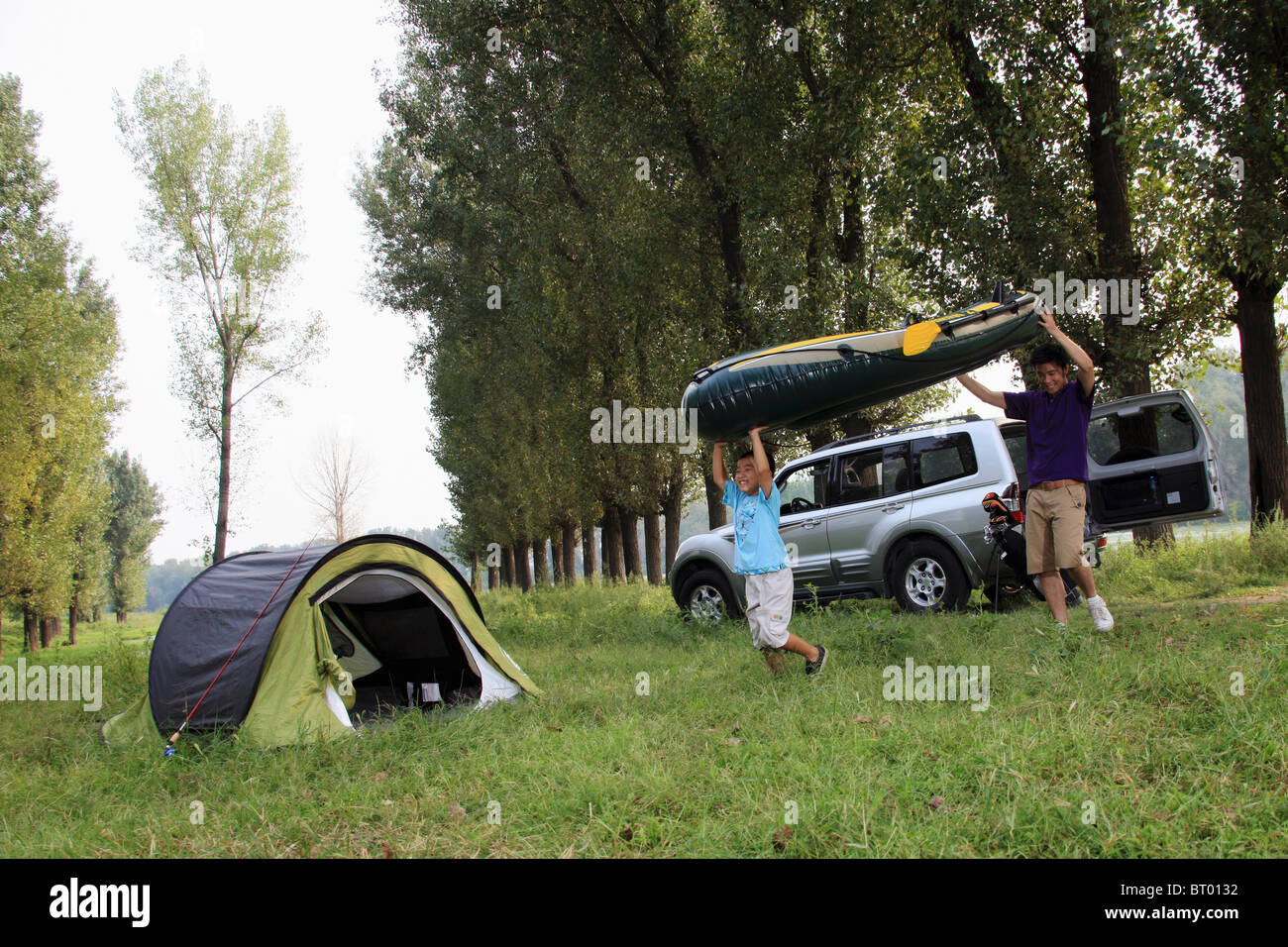 Boy and his son carring an inflatable raft Stock Photo - Alamy
