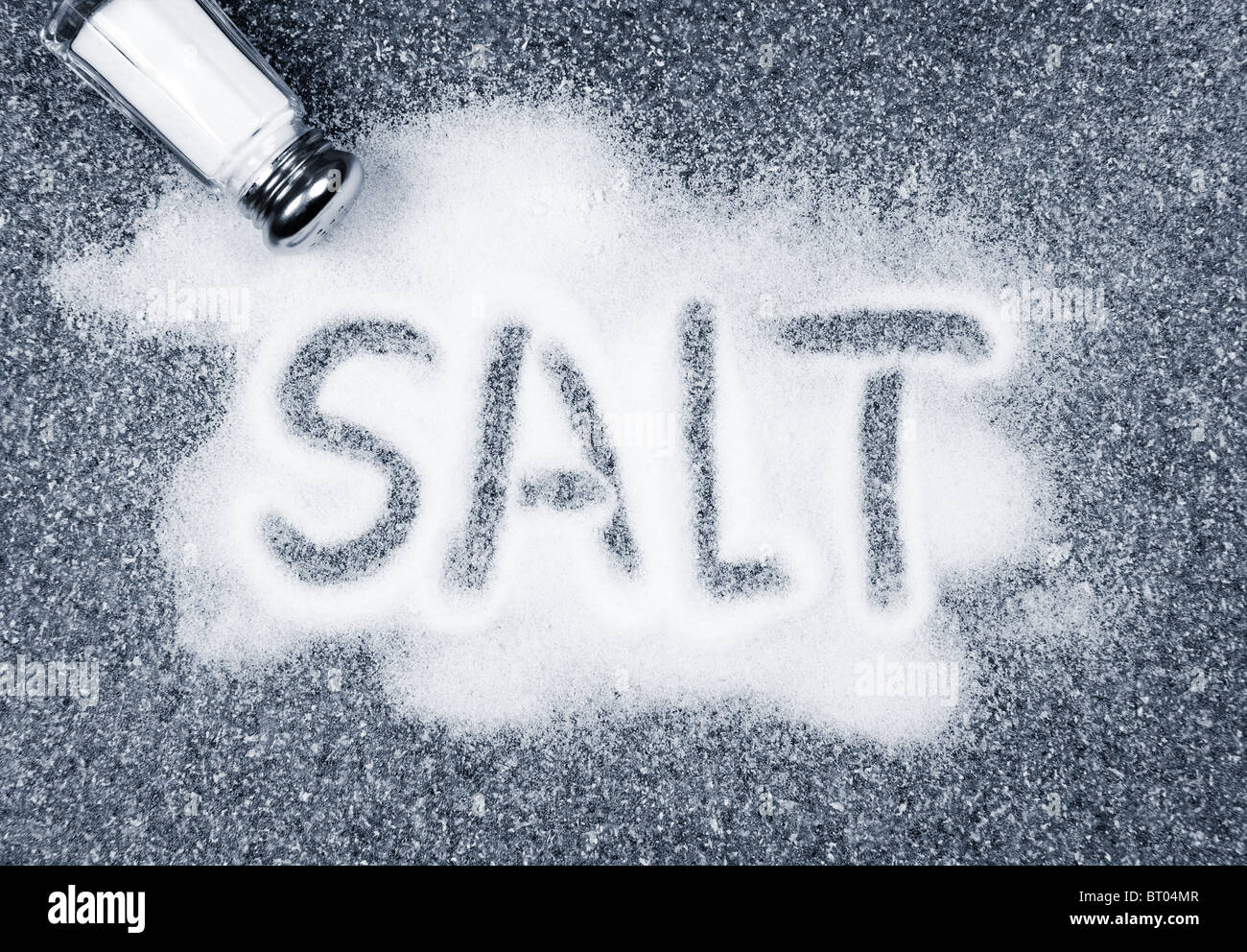 Salt written on counter in spilled salts from shaker Stock Photo - Alamy