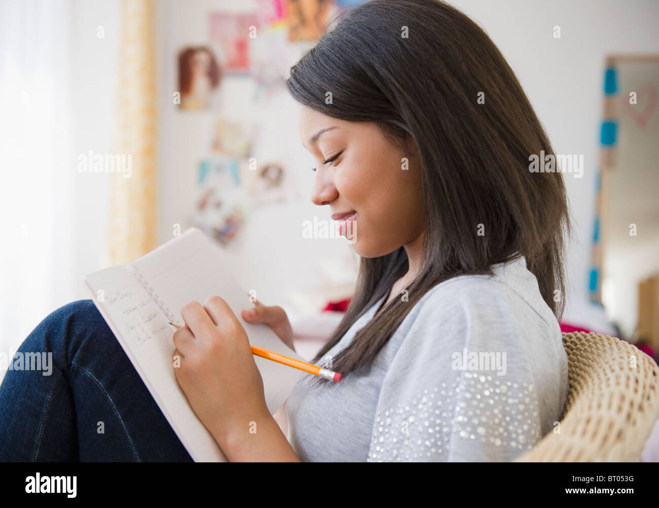 Smiling mixed race teenage girl writing in journal Stock Photo - Alamy