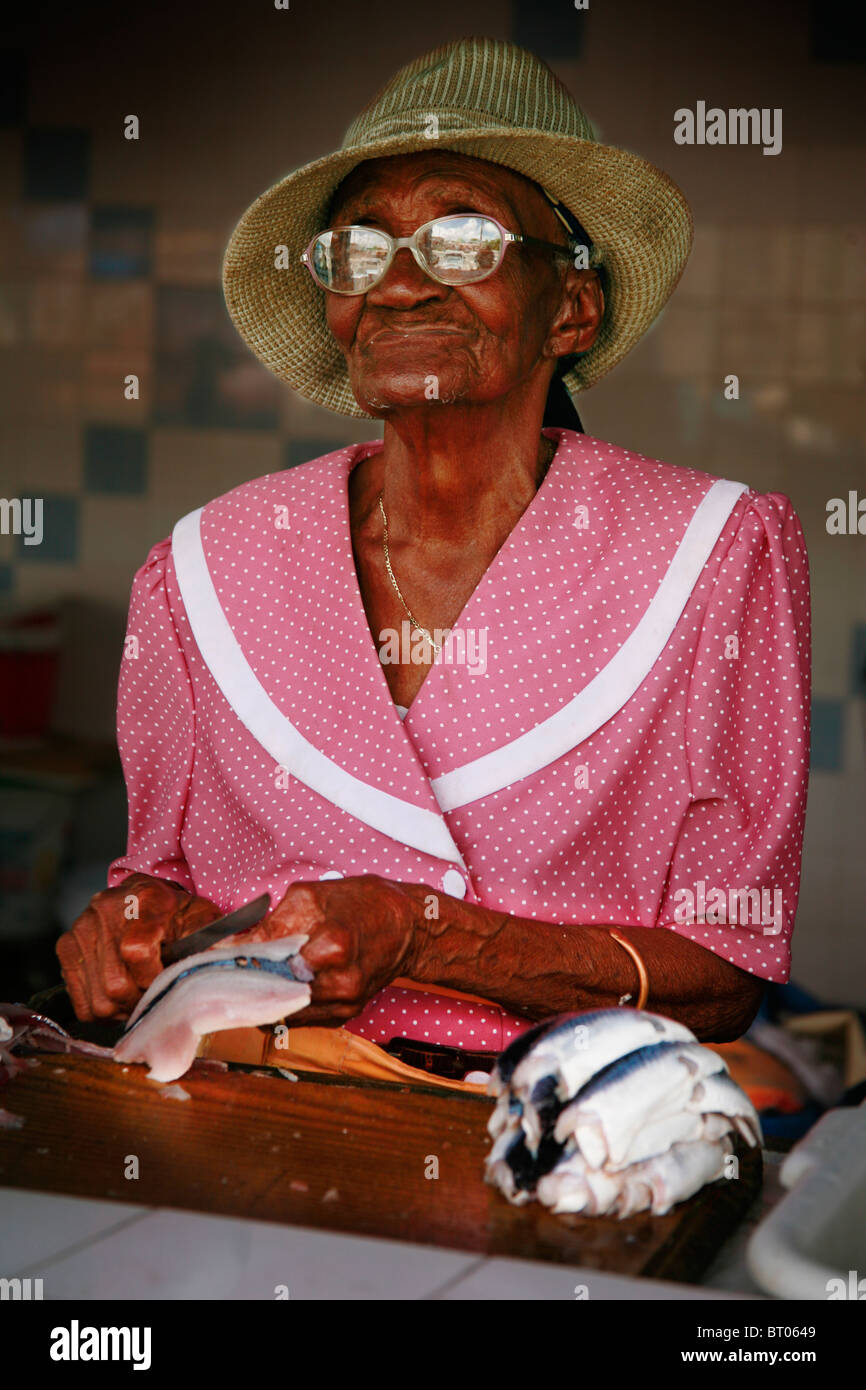 A woman prepares fillets of fish at a purpose-built fish stall by the ...