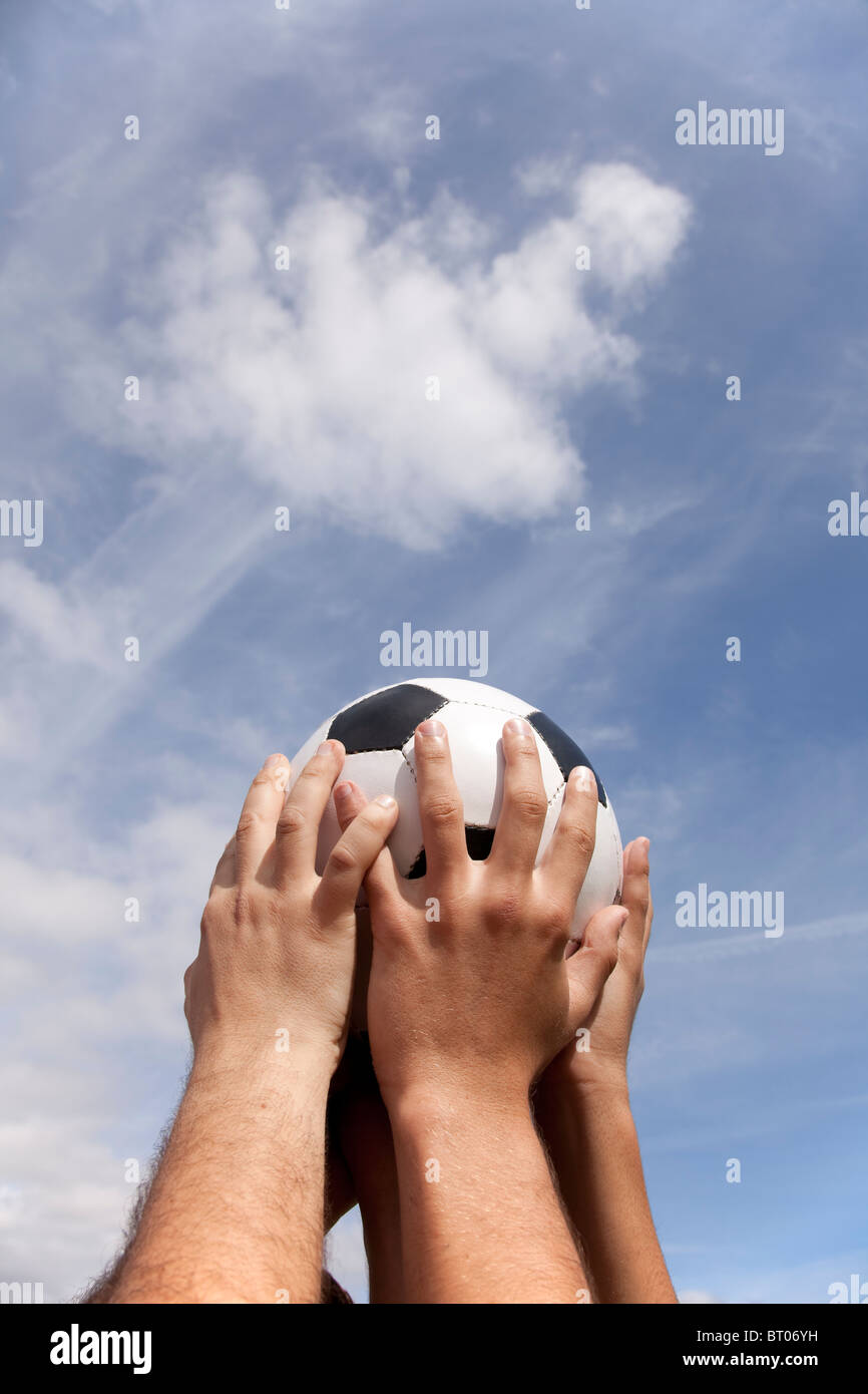 Soccer team raising a ball to the sky Stock Photo - Alamy